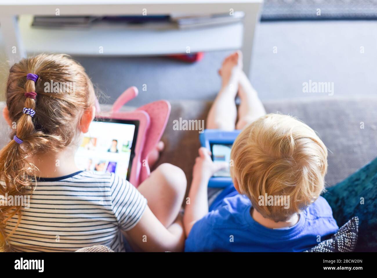 Children using their tablet device to play computer games and use ...