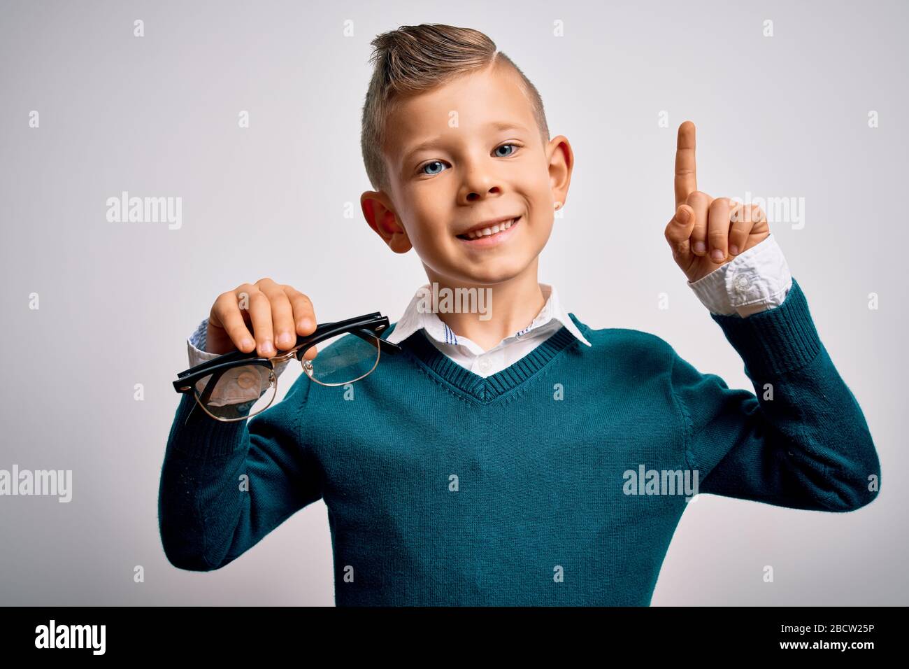 Young little caucasian kid holding eyesight glasses correction over ...