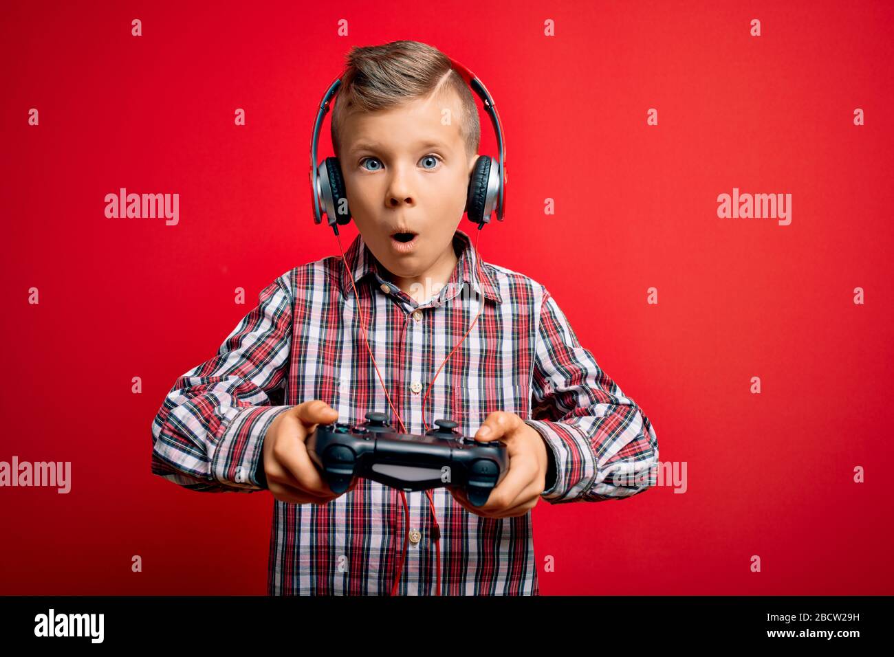 Young little caucasian gamer kid playing video games using gamepad ...