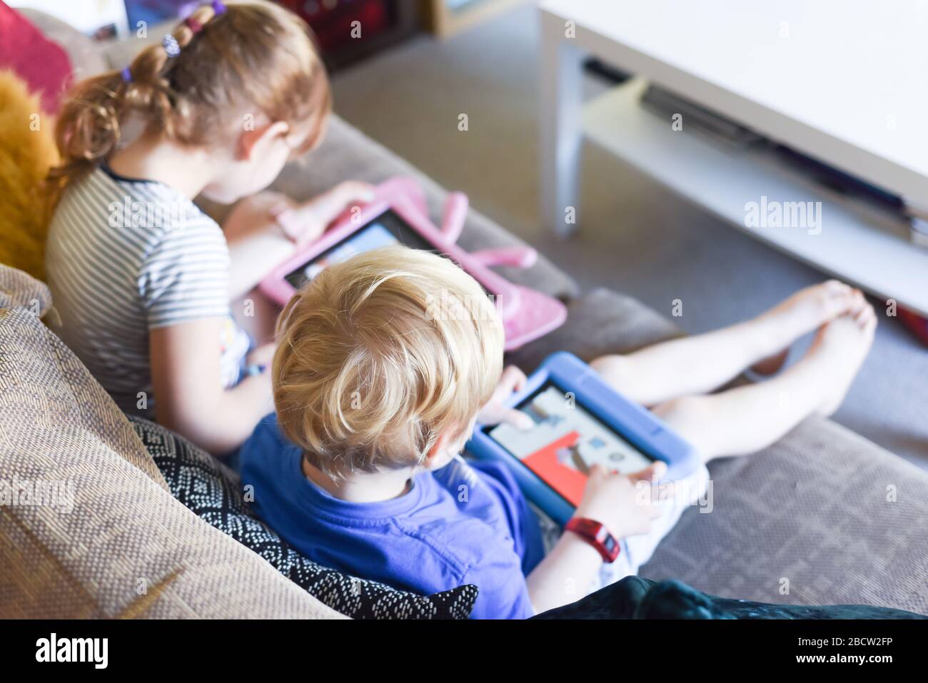 Children using their tablet device to play computer games and use ...