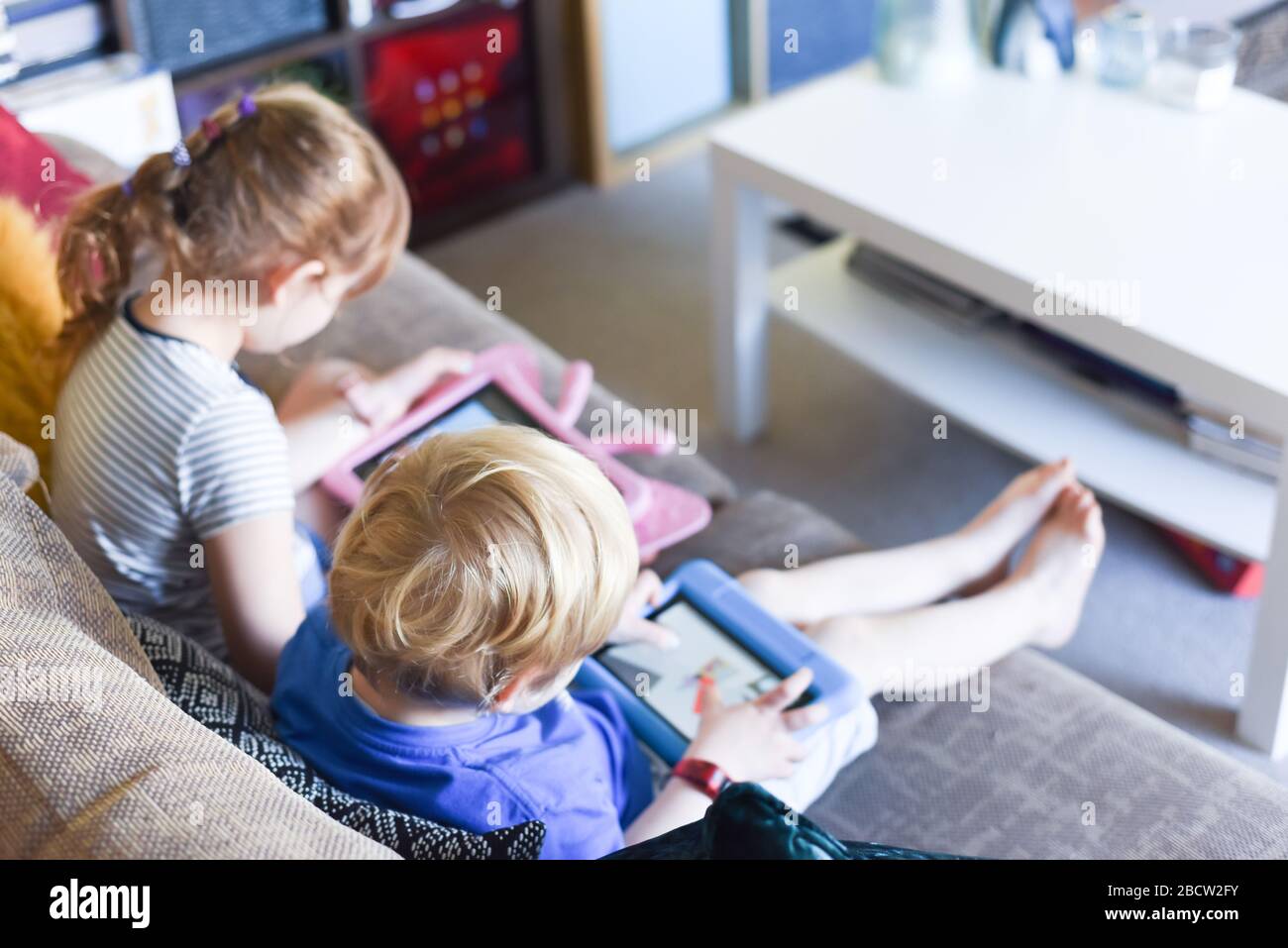 Children using their tablet device to play computer games and use ...