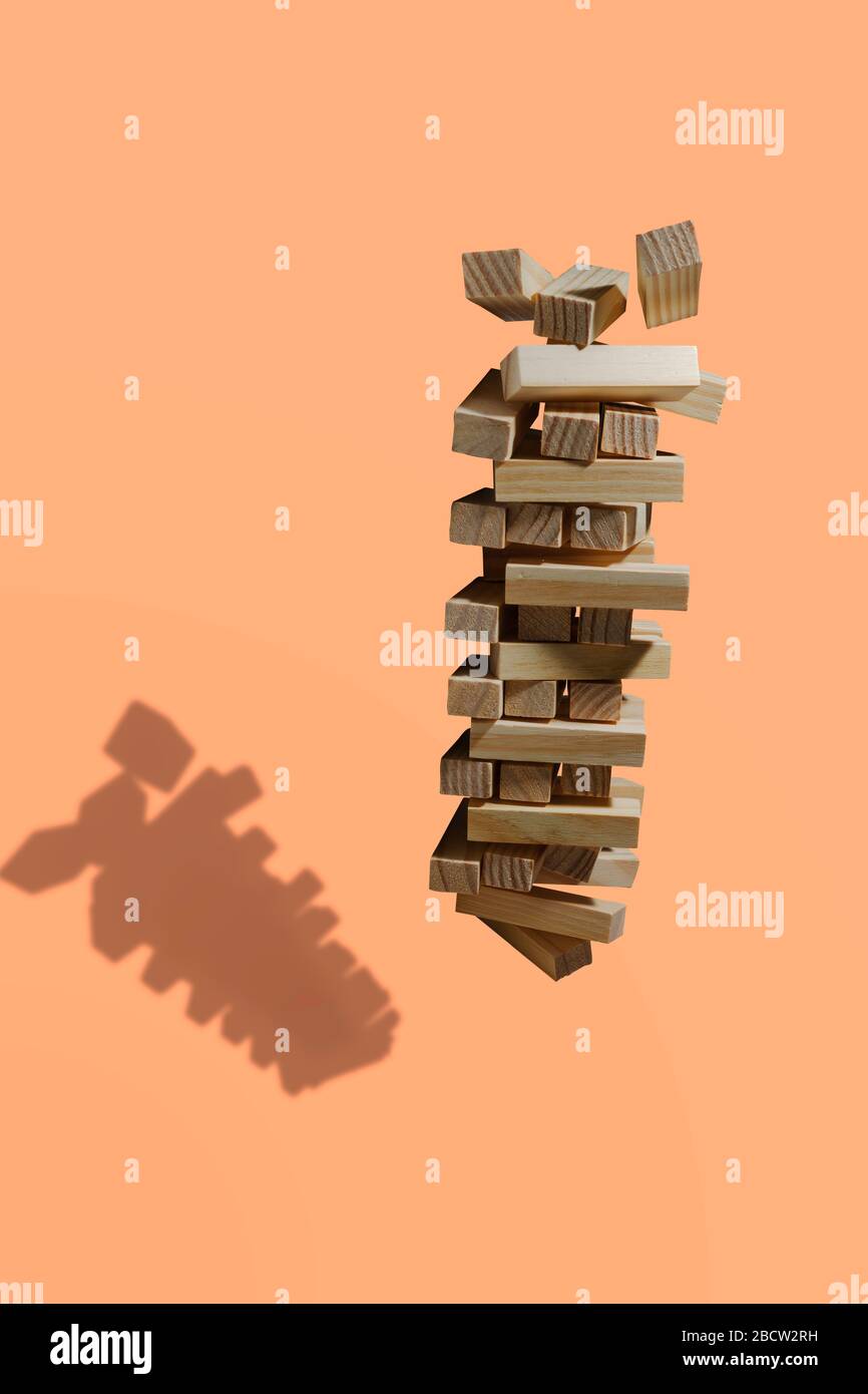 Wooden block tower game collapses isolated on orange background with ...