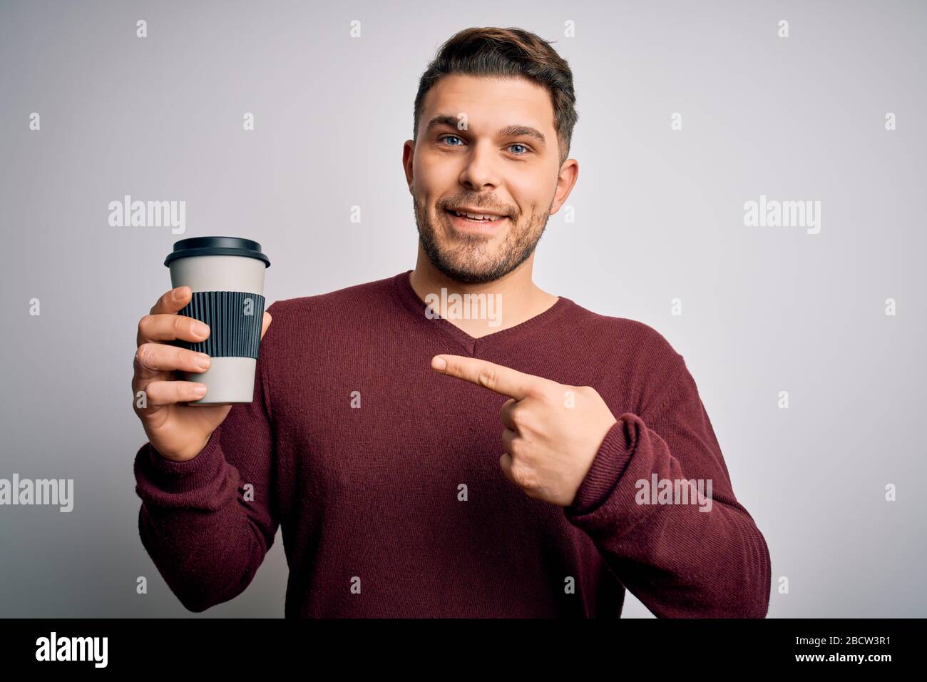 Young man with blue eyes drinking coffee from take away plastic bottle ...