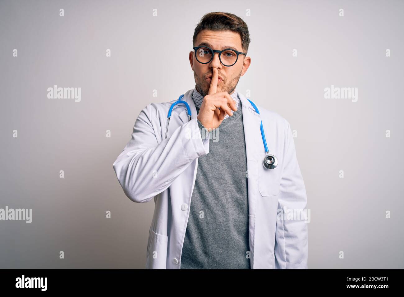 Young doctor man with blue eyes wearing medical coat and stethoscope ...
