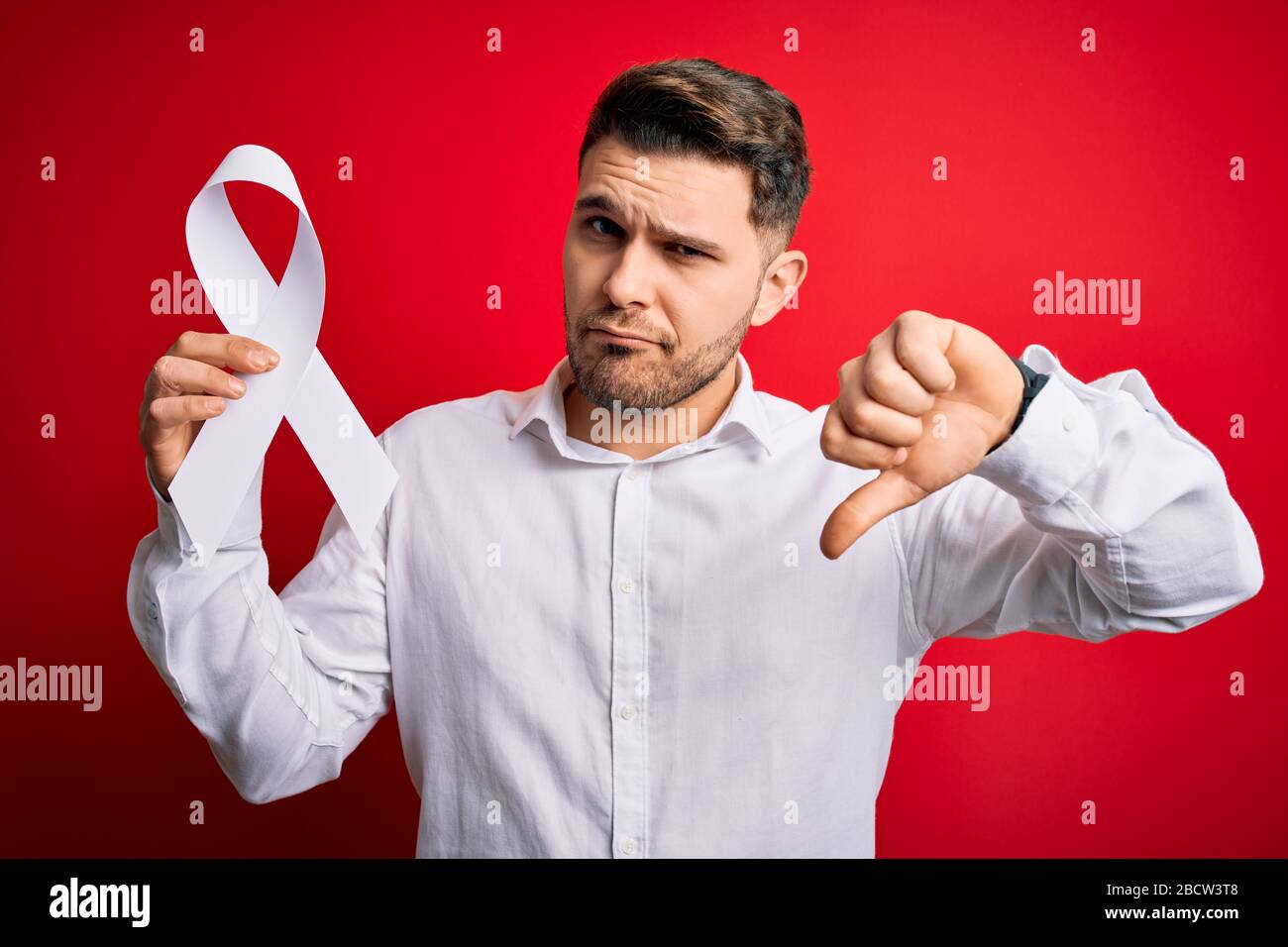 Young man with blue eyes holding white ribbon as lung cancer awareness ...