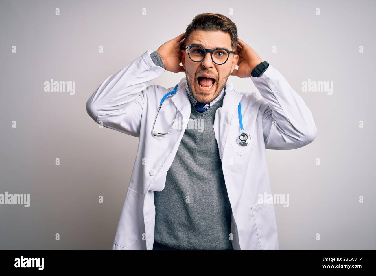 Young doctor man with blue eyes wearing medical coat and stethoscope ...