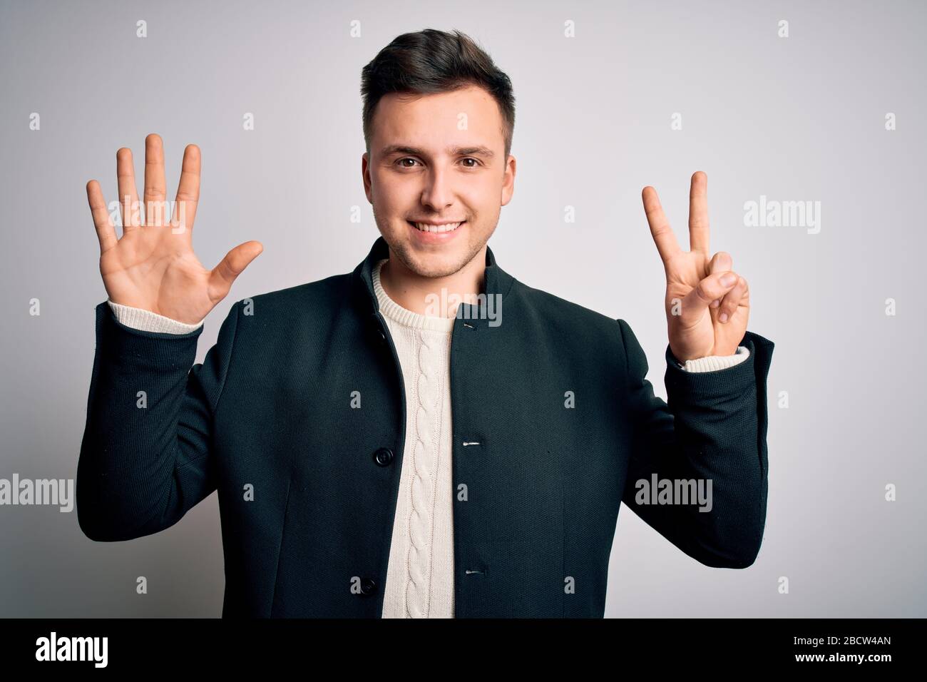 Young handsome business mas wearing elegant winter coat standing over ...