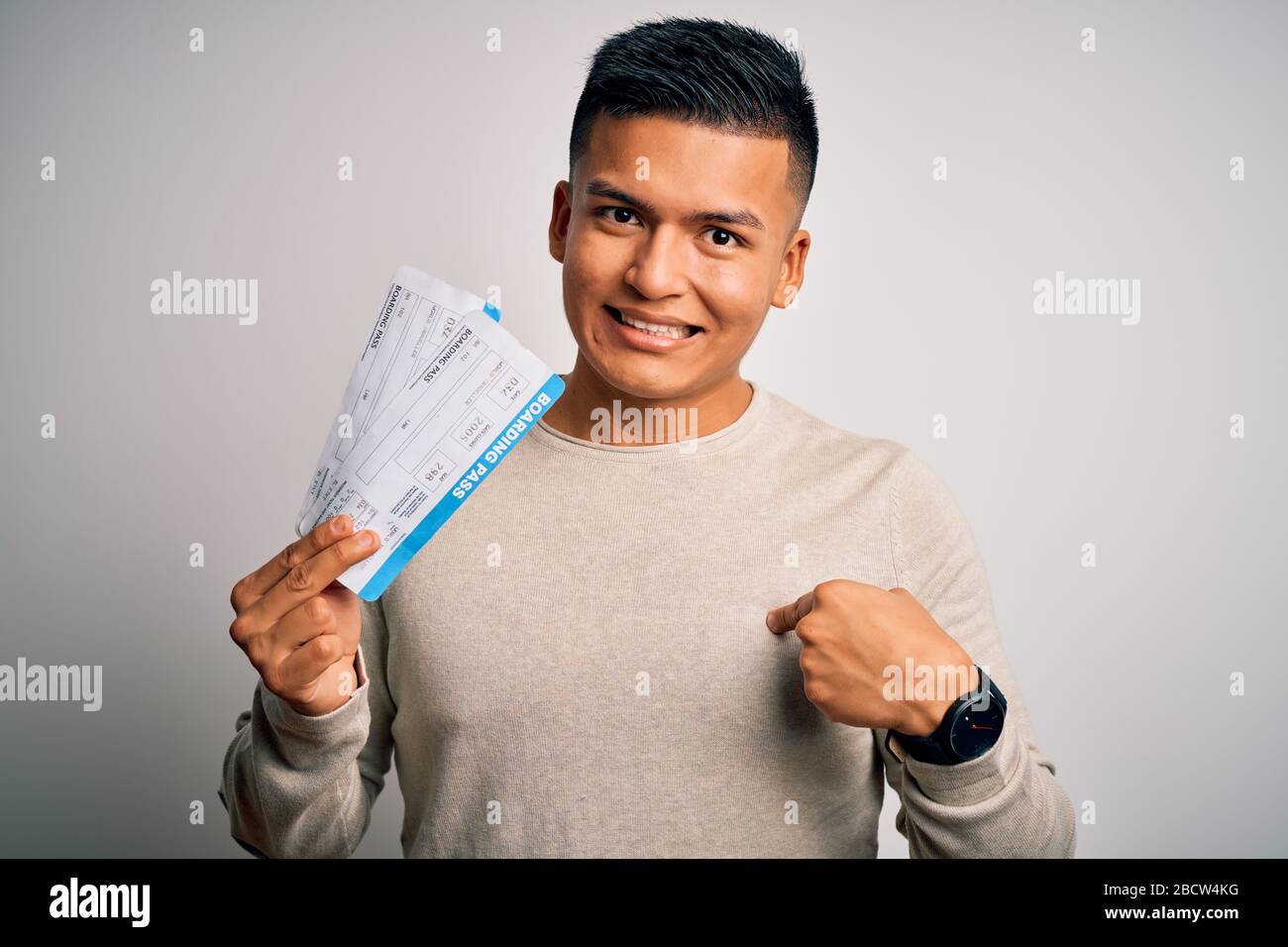 Young handsome latin tourist man on vacation holding airline boarding ...
