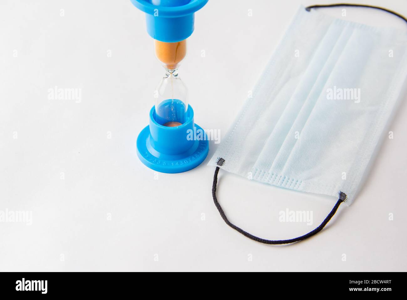 Medical mask and hourglass on a white background Stock Photo - Alamy