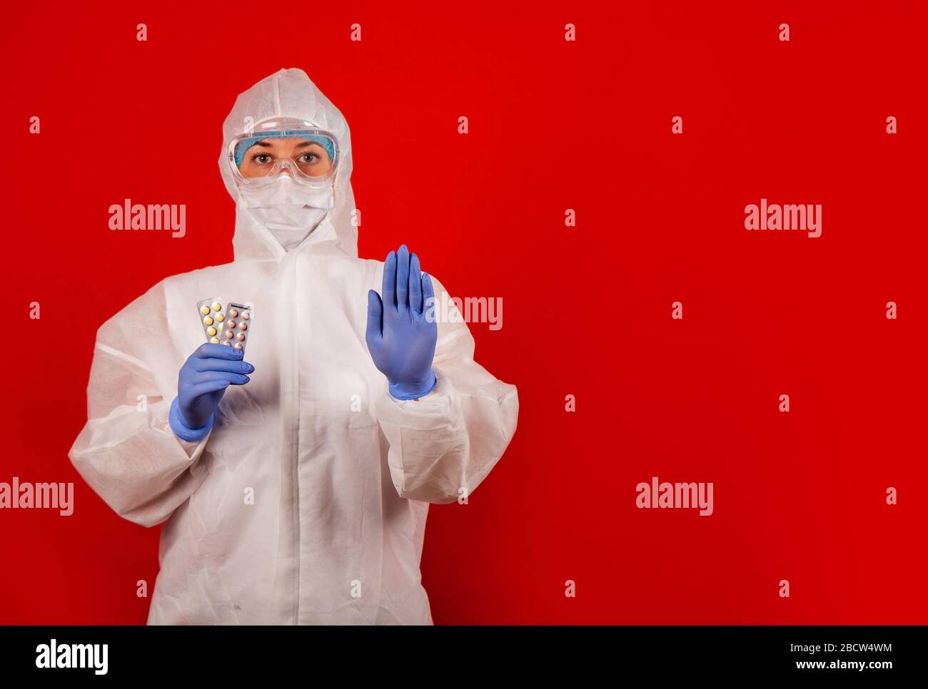 A doctor in a medical overalls shows a stop gesture. Young professional ...