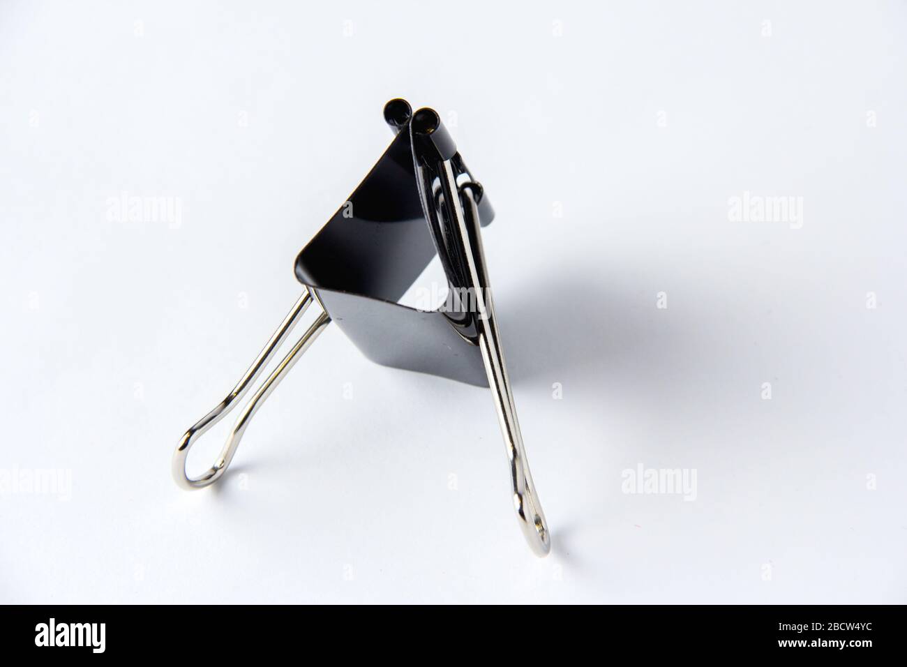Large black paper clip for papers on white background. Stacking papers ...