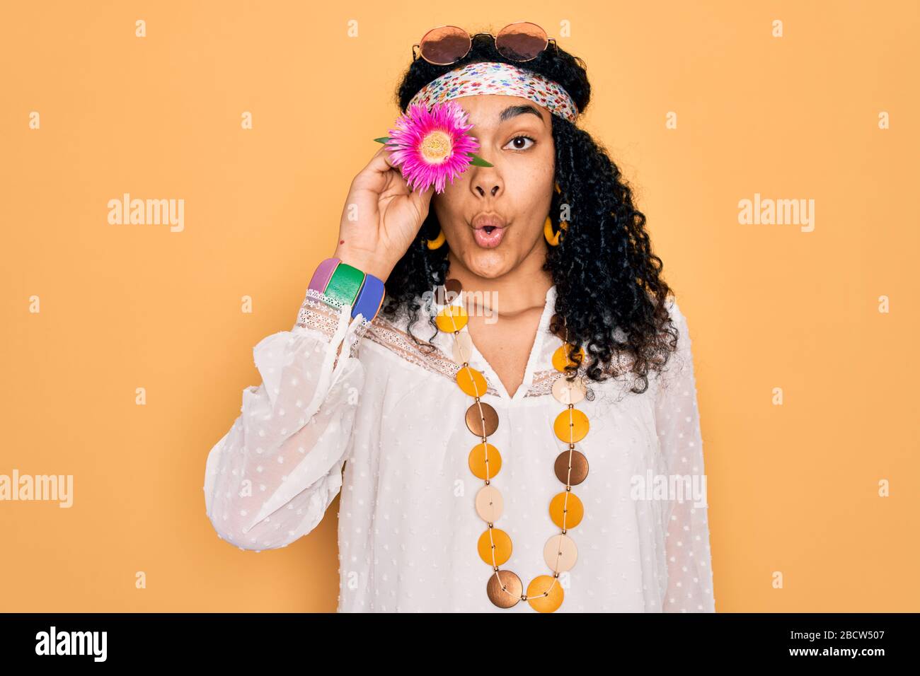 Young african american curly hippie woman wearing sunglasses holding ...