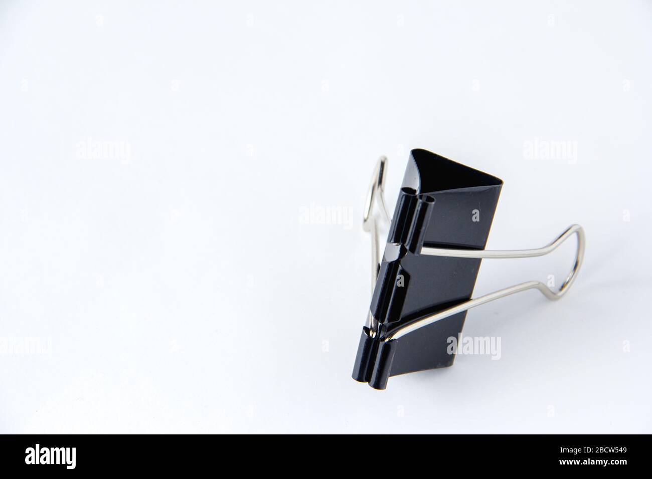 Large black paper clip for papers on white background. Stacking papers ...