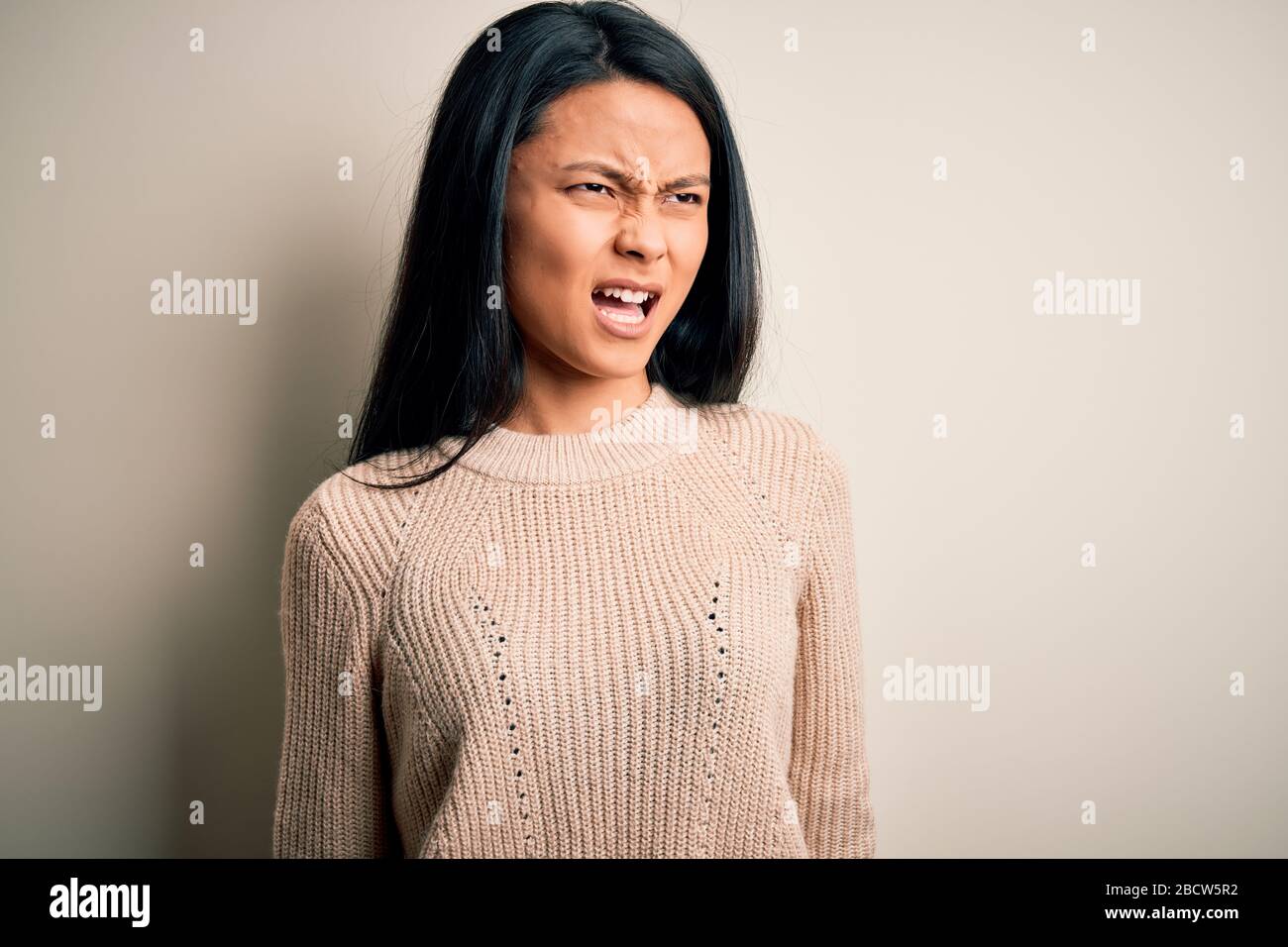 Young beautiful chinese woman wearing casual sweater over isolated ...