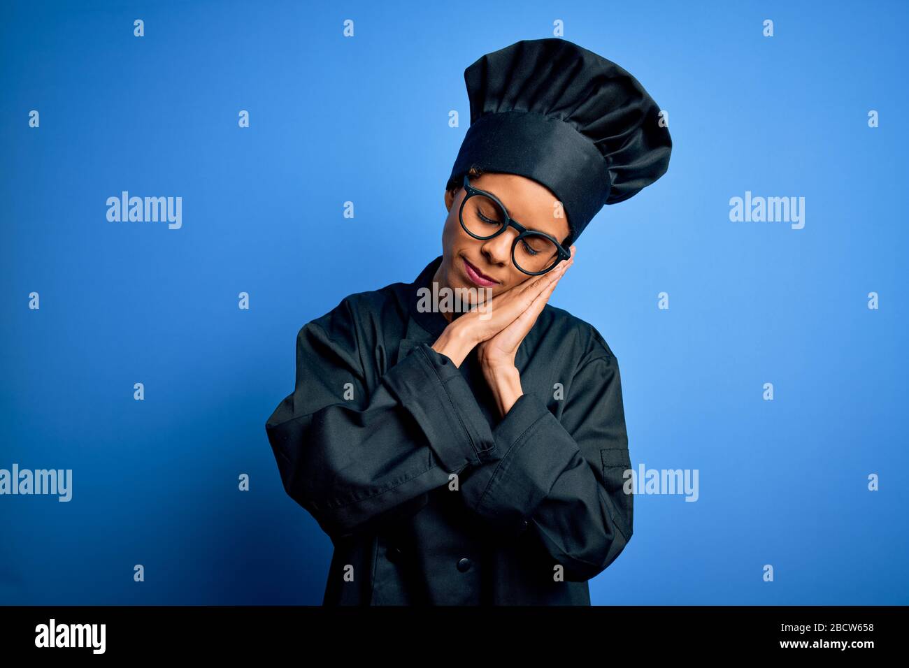 Young african american chef woman wearing cooker uniform and hat over ...