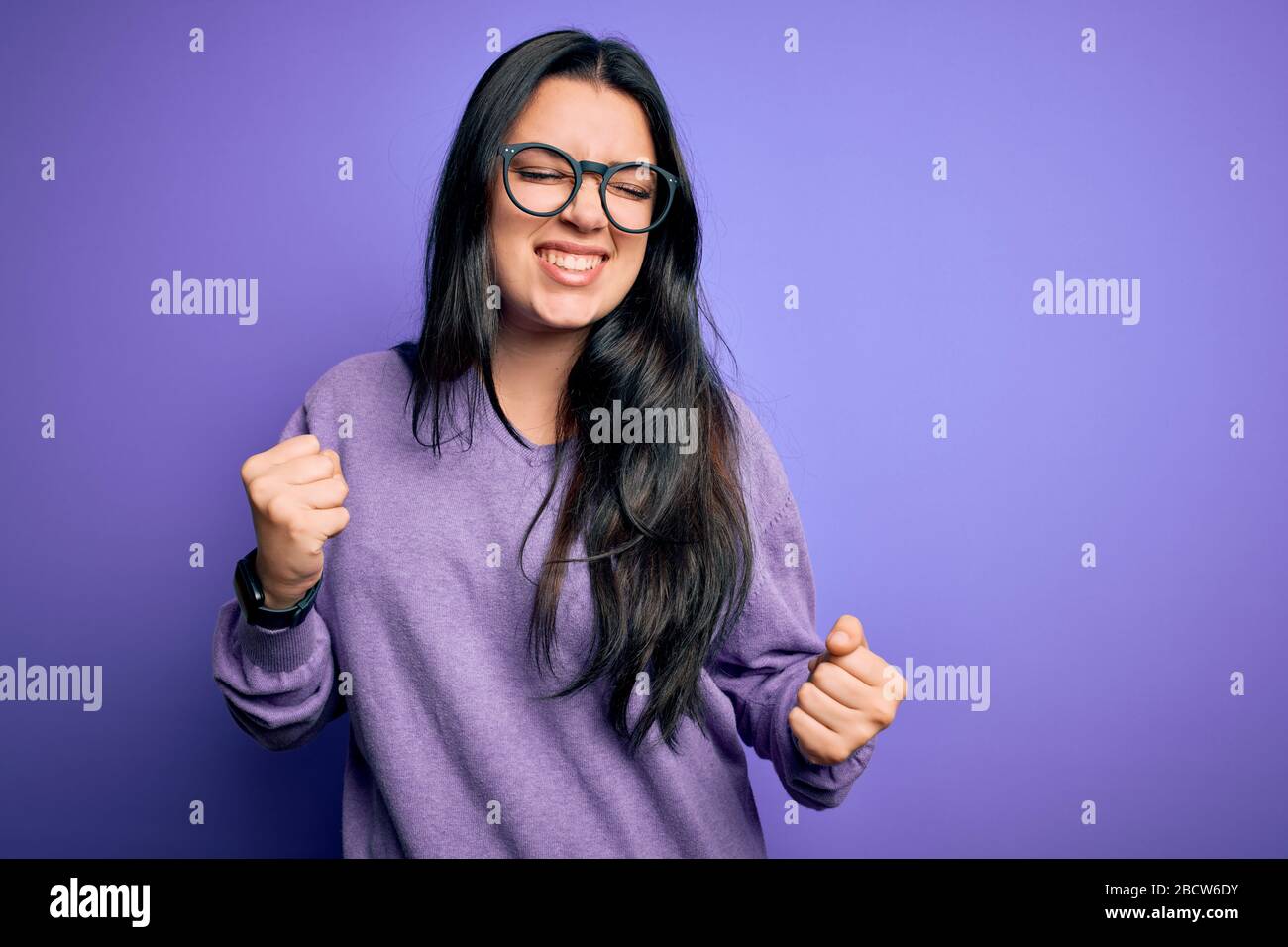 Young brunette woman wearing glasses over purple isolated background ...