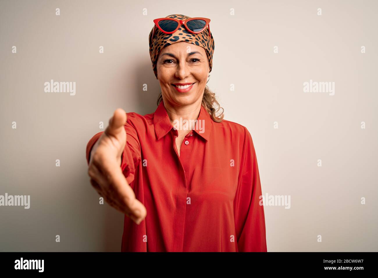 Middle age brunette woman wearing handkerchief on head and shirt over ...