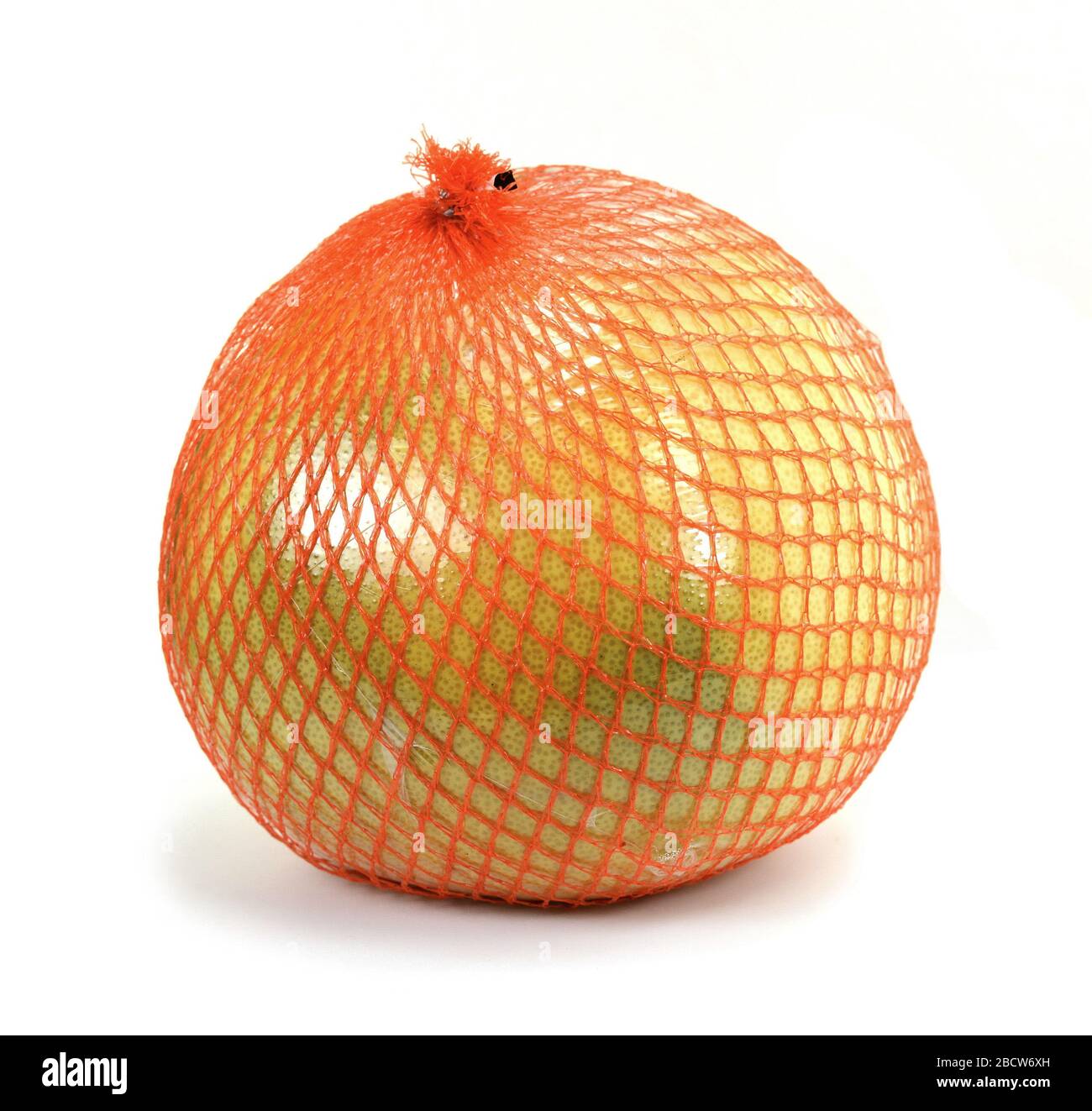 A ripe pomelo is packaged in a grid. Pomelo isolated on a white ...