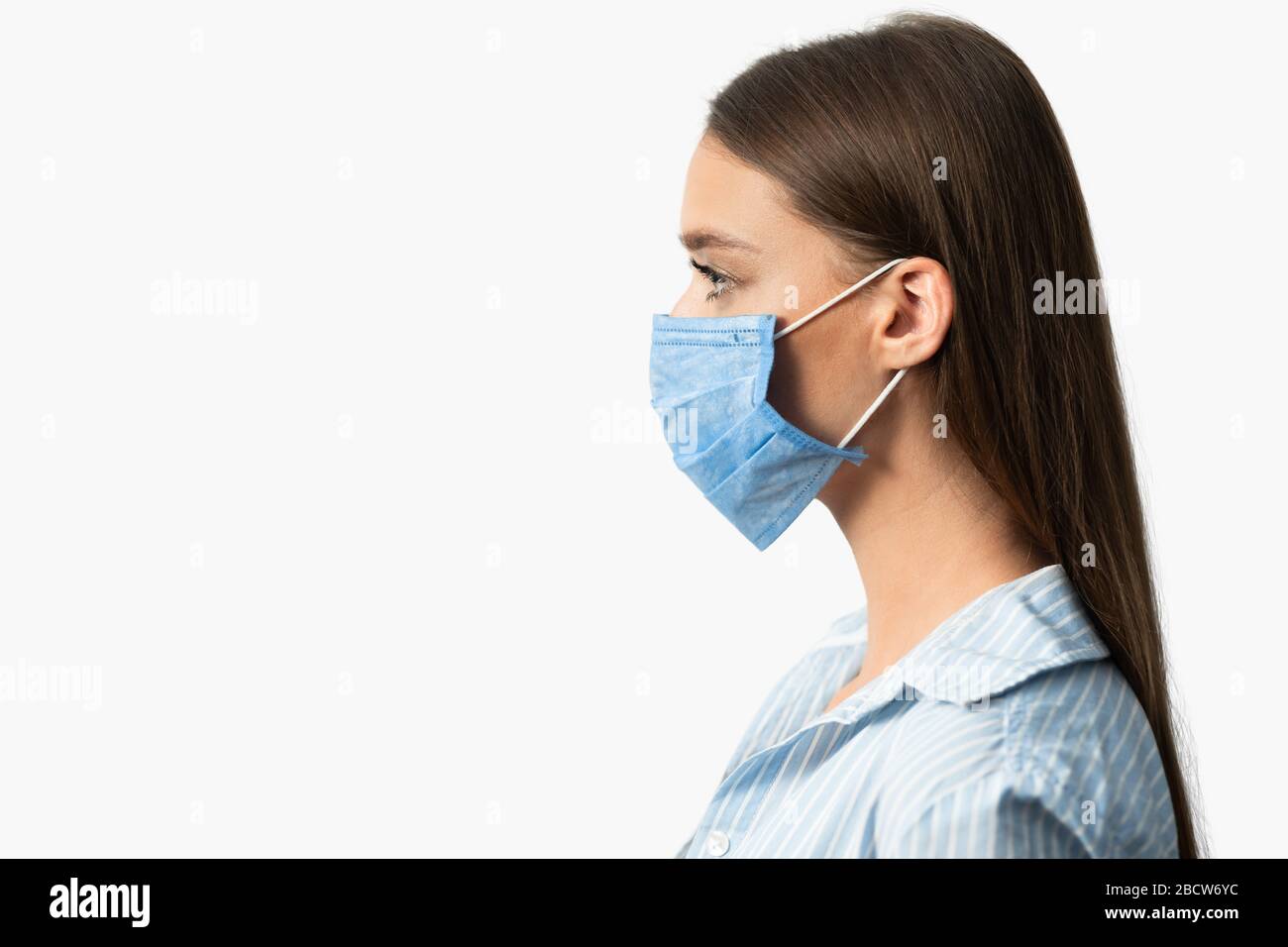 Girl In Medical Mask Posing On White Studio Background, Side-View Stock ...