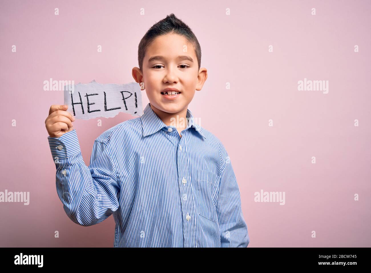 Young little boy kid holding paper sing with help message asking for ...