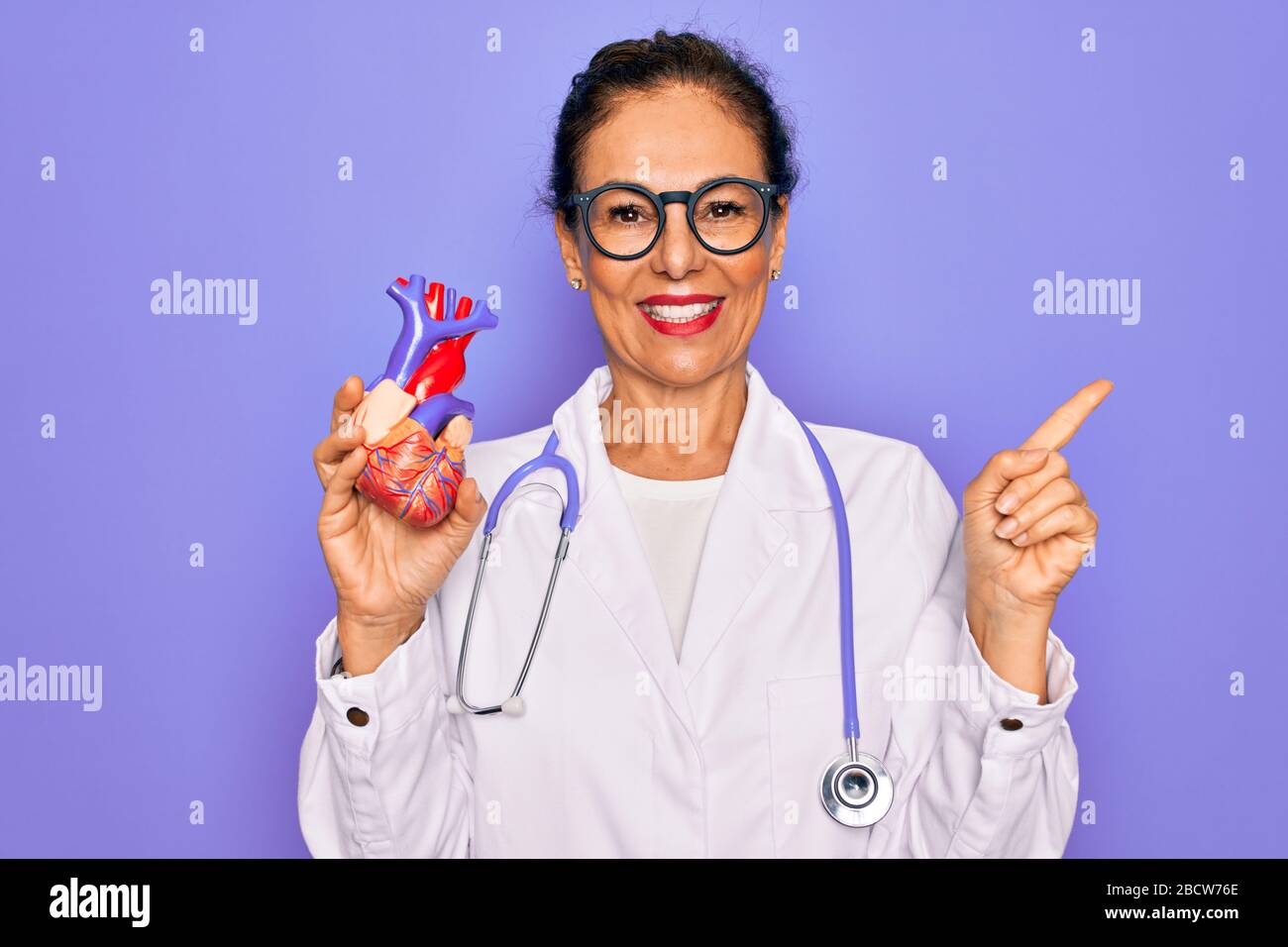 Middle age senior cardiologist doctor woman holding professional ...