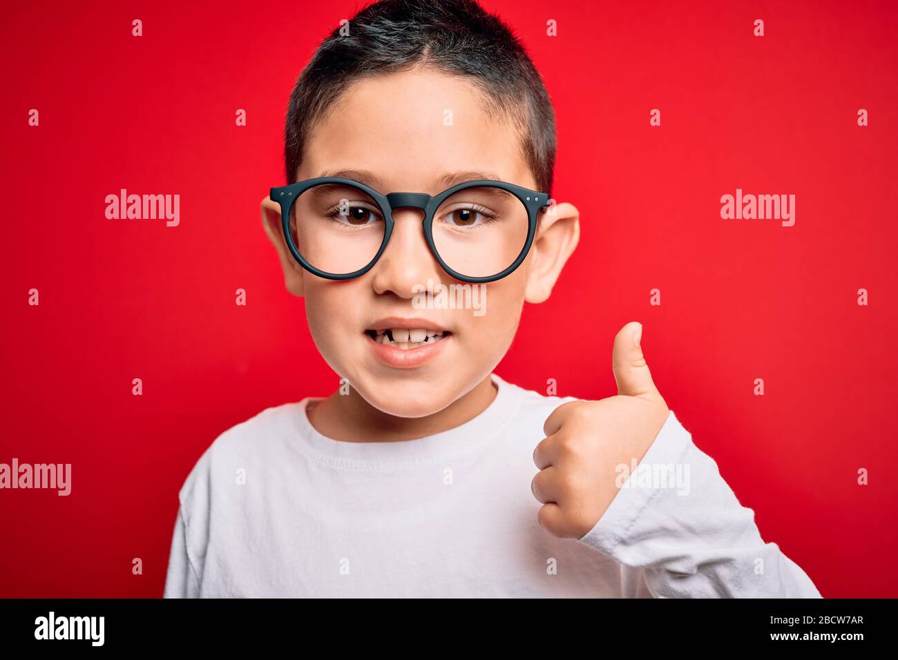 Young little smart boy kid wearing nerd glasses over red isolated ...