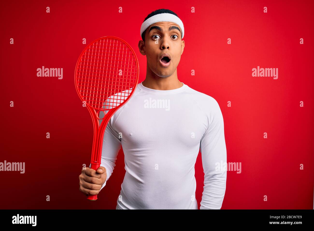 Young handsome african american sportsman playing tennis using racket ...