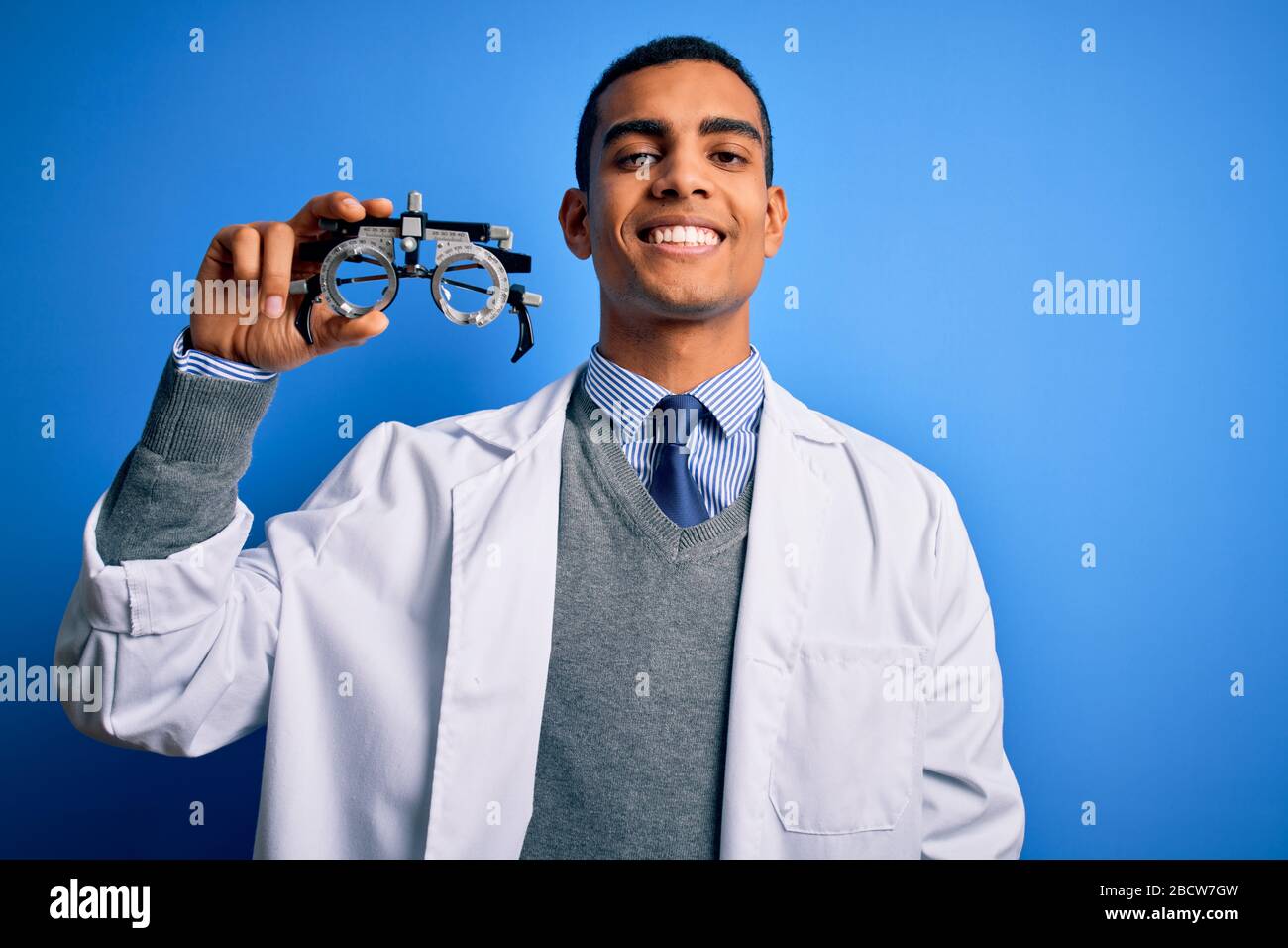 Handsome african american optical man holding optometry glasses over ...