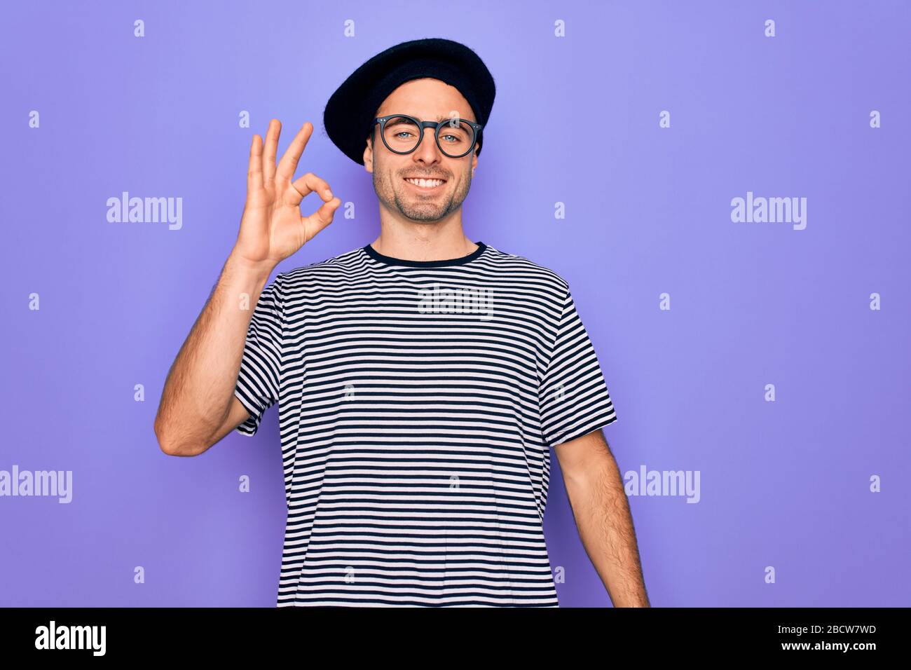 Handsome man with blue eyes wearing striped t-shirt and french beret ...
