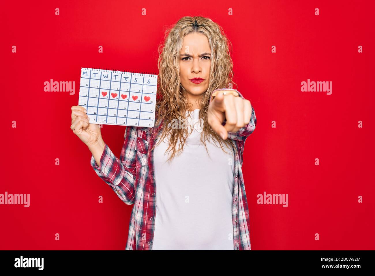 Young beautiful blonde woman holding period calendar controlling ...