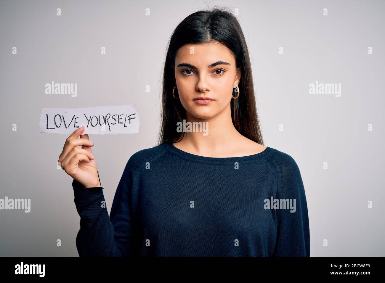 Young beautiful woman asking for take care of you holding paper with ...