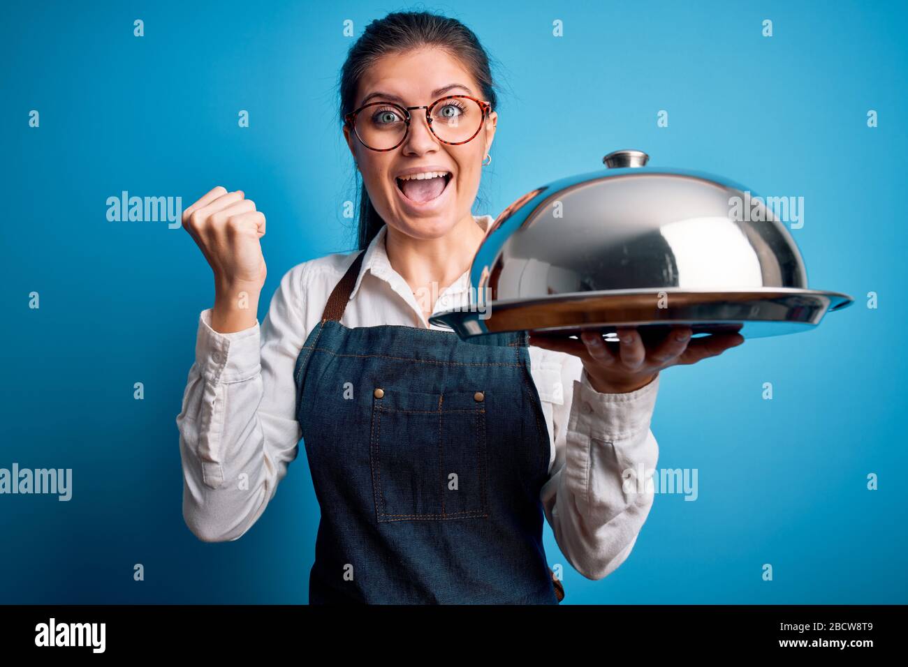 Young beautiful waitress woman with blue eyes holding tray with dome ...