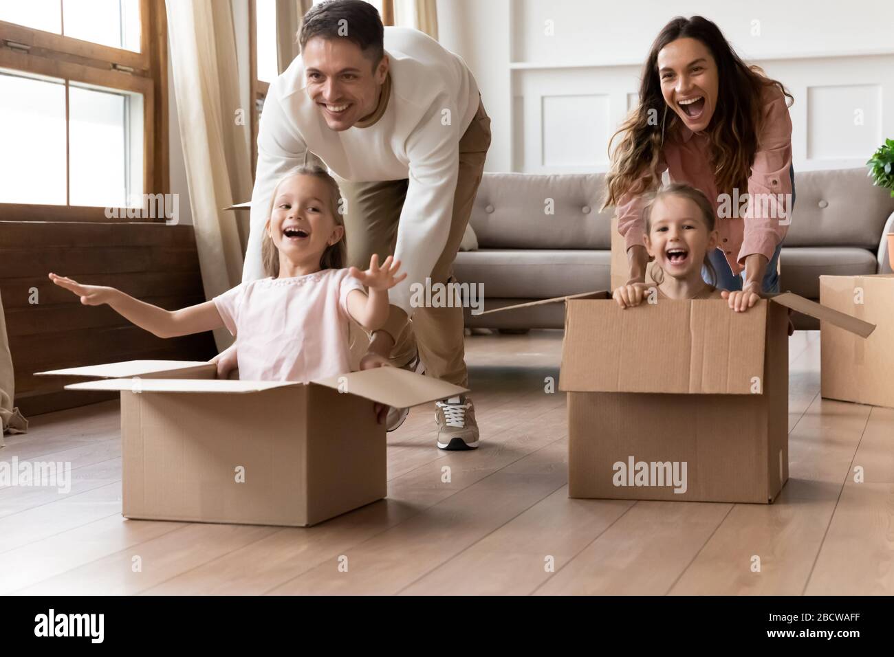 Laughing family couple having fun together with adorable daughters ...