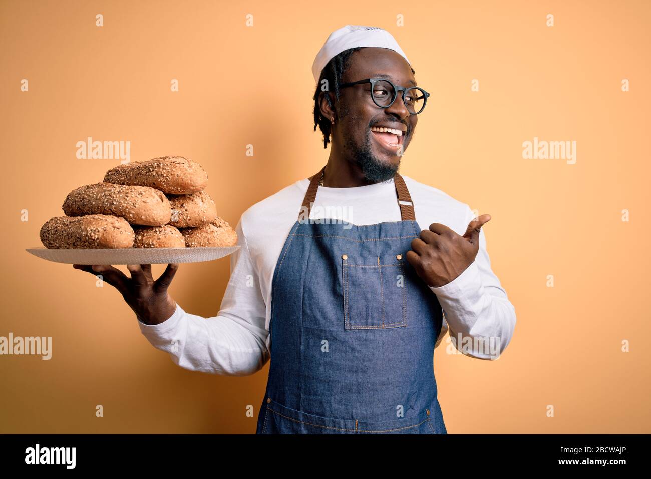 Young african american bakery man holding tray with healthy wholemeal ...