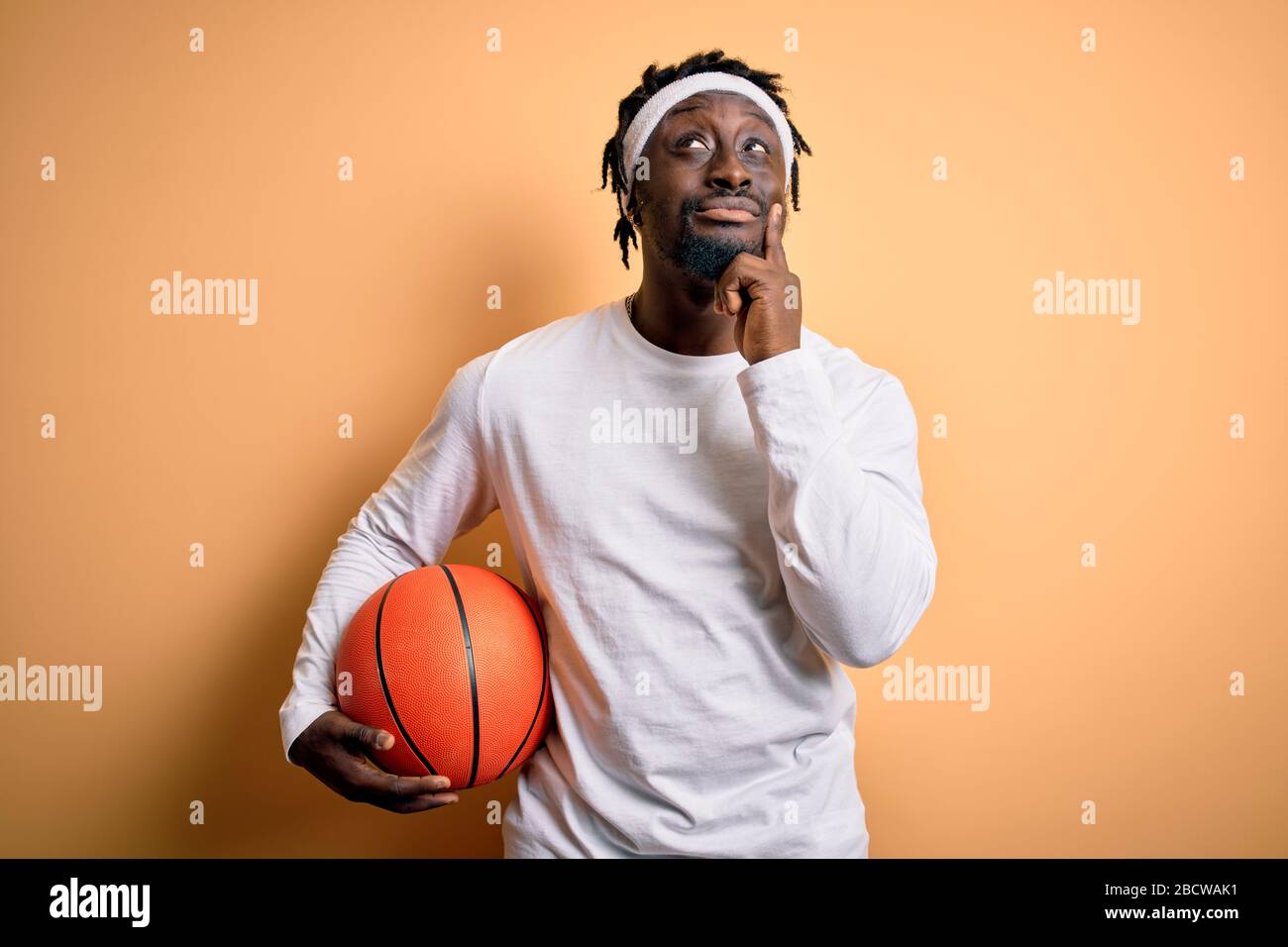 Young african american sportsman doing sport holding basketball ball ...