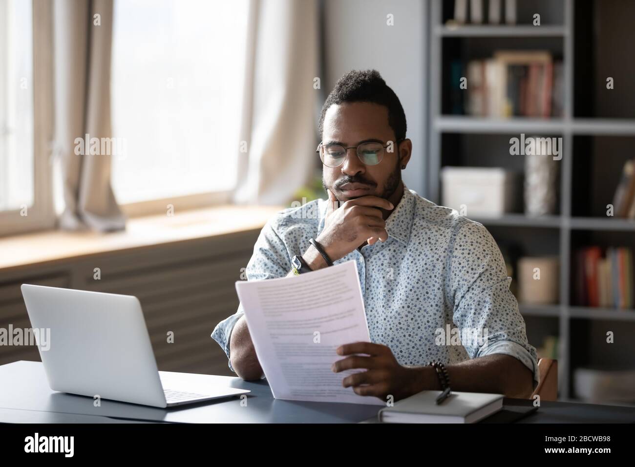 African guy reading paper hi-res stock photography and images - Alamy