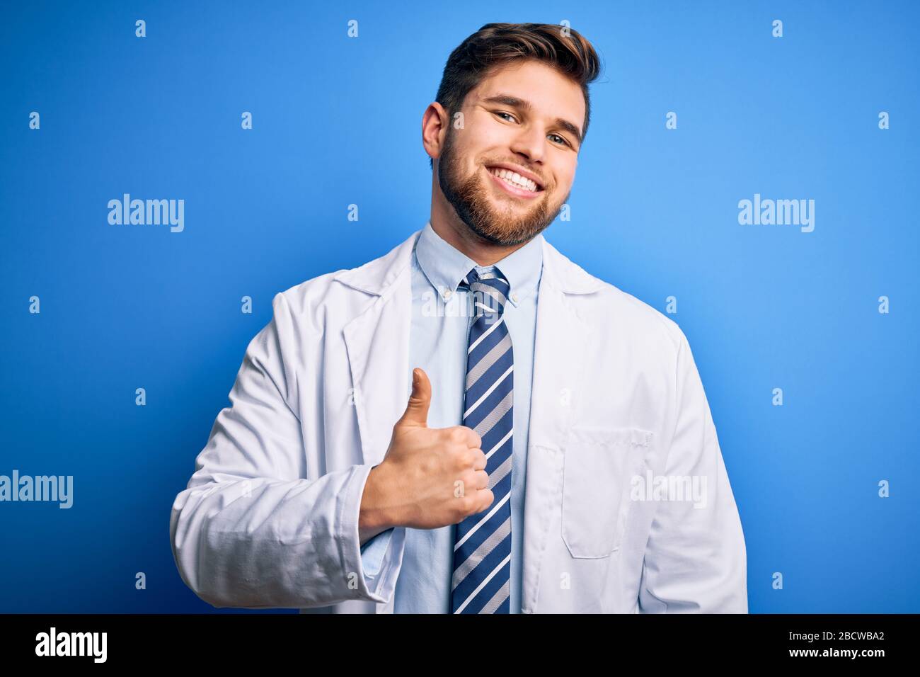 Young blond therapist man with beard and blue eyes wearing coat and tie ...