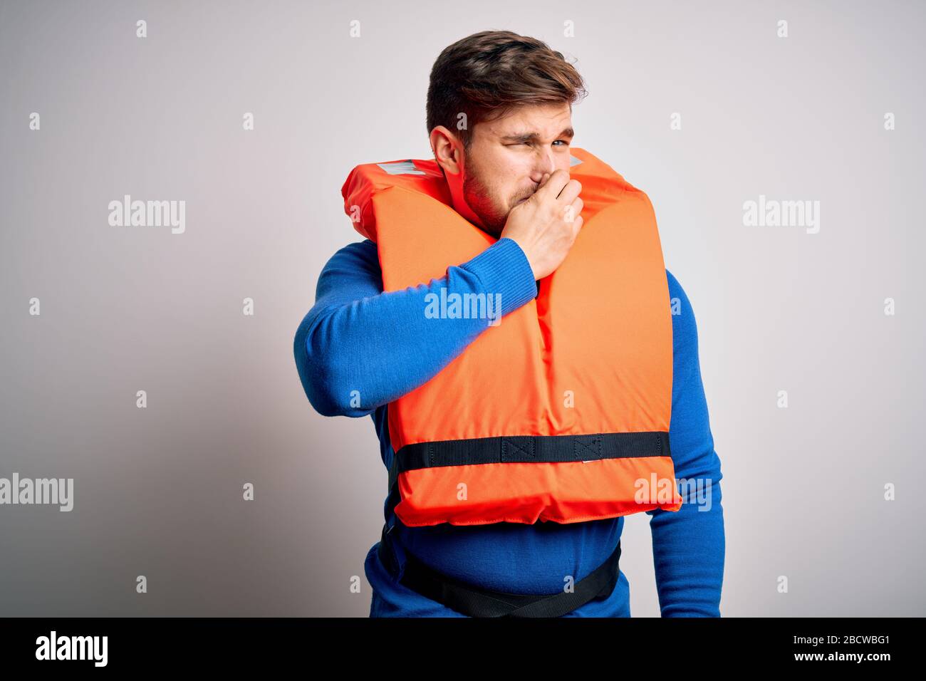 Young blond tourist man with beard and blue eyes wearing lifejacket ...