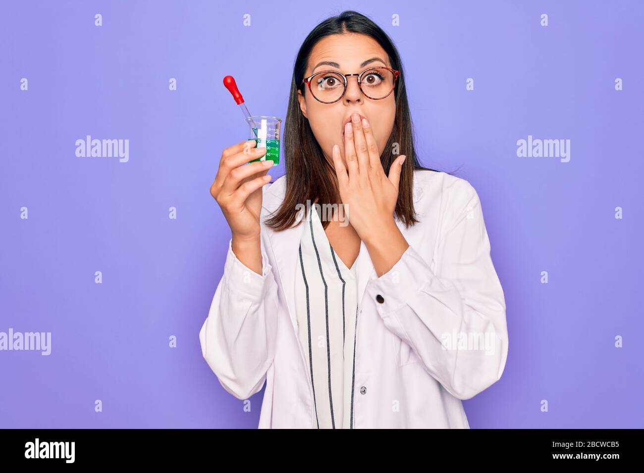 Young beautiful brunette scientist woman wearing coat and glasses ...