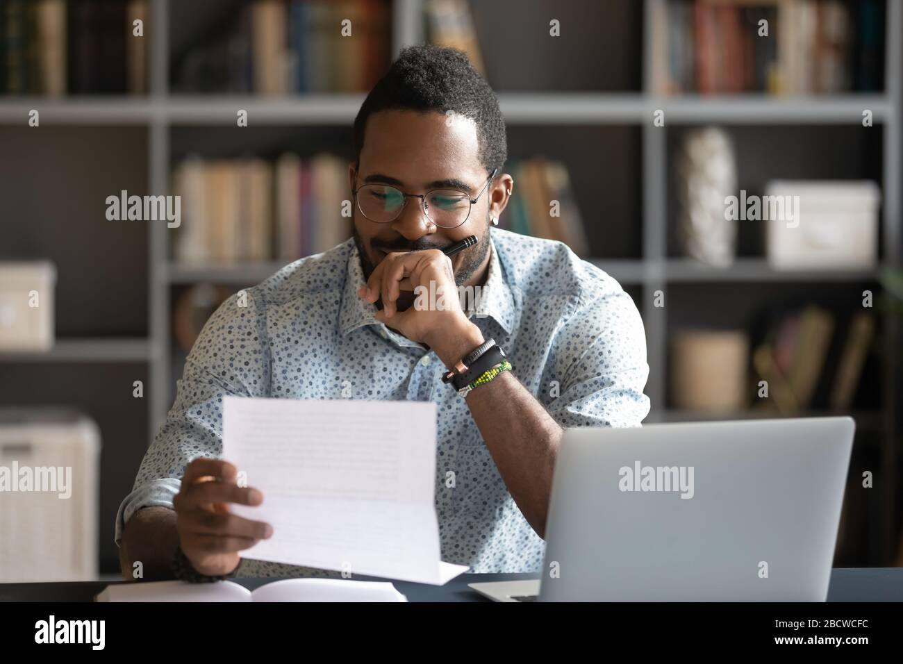 Pensive african American man reading letter in office Stock Photo - Alamy