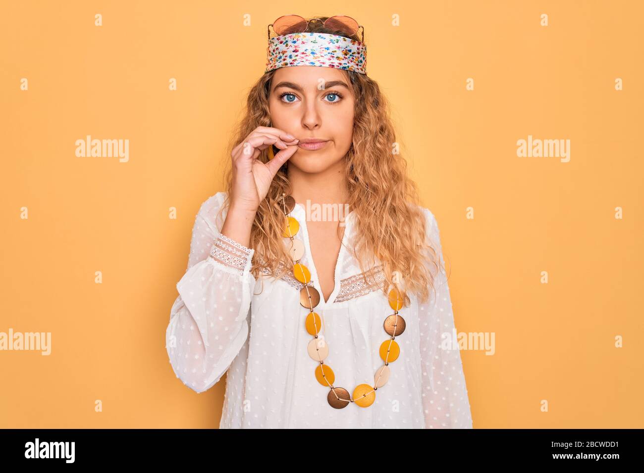 Young beautiful blonde hippie woman with blue eyes wearing sunglasses ...