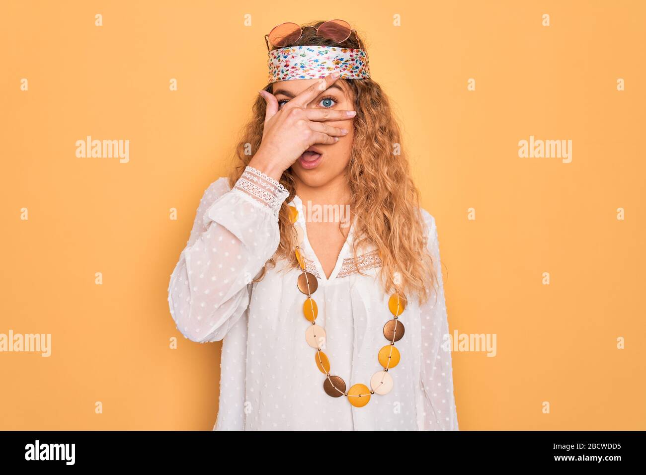 Young beautiful blonde hippie woman with blue eyes wearing sunglasses ...