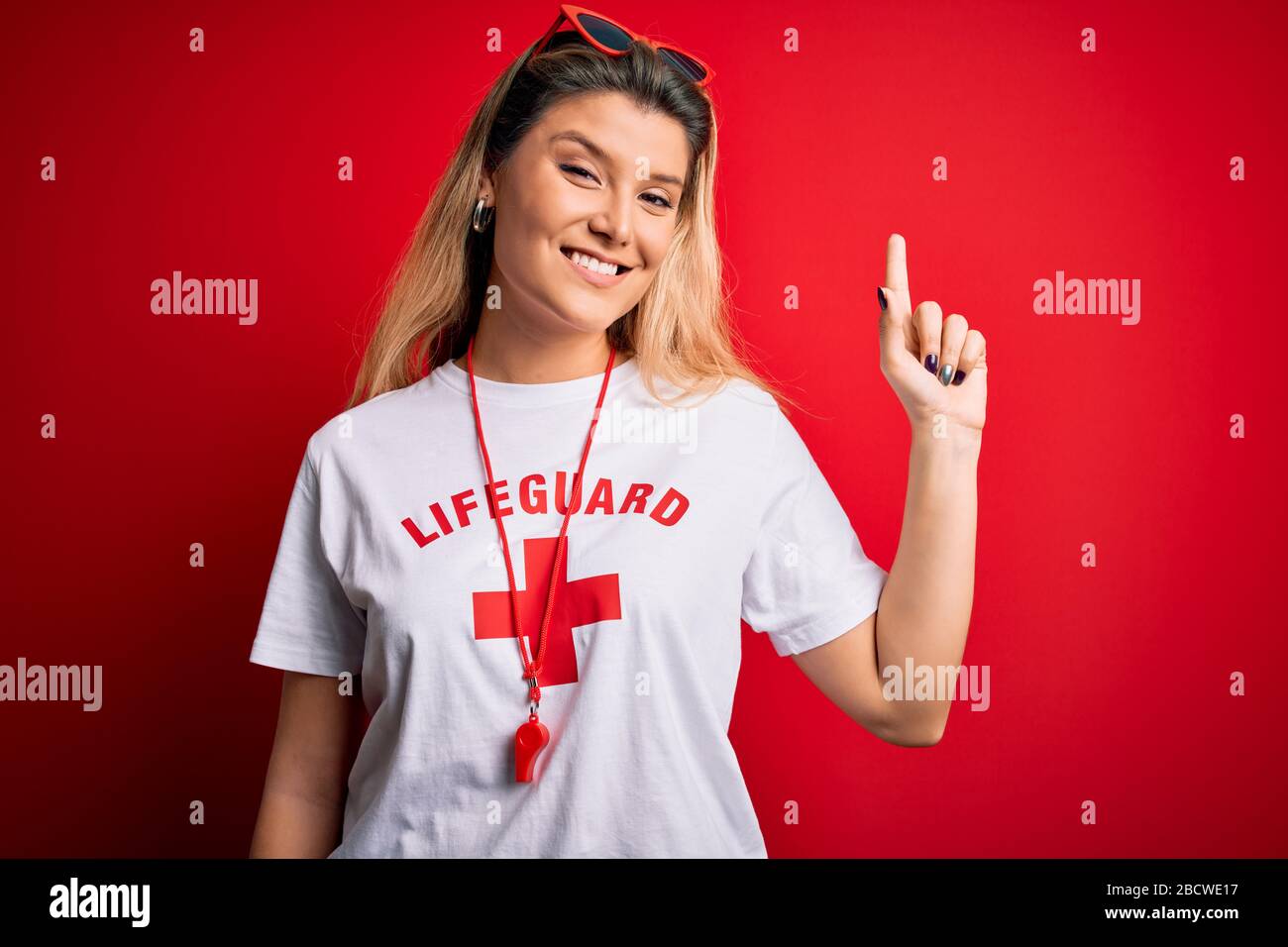 Young beautiful blonde lifeguard woman wearing t-shirt with red cross ...