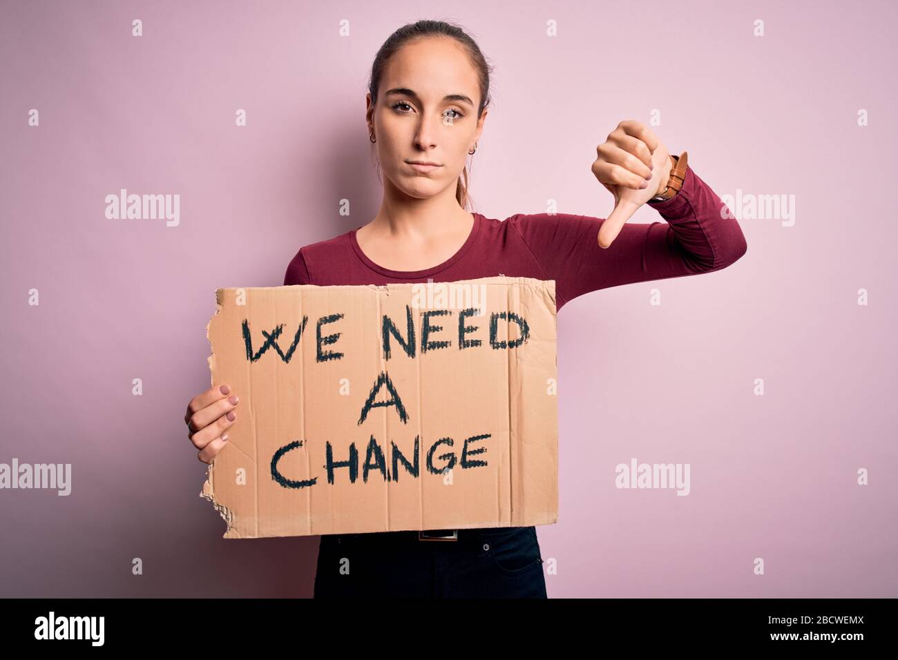 Young beautiful activist woman asking for change protesting holding ...