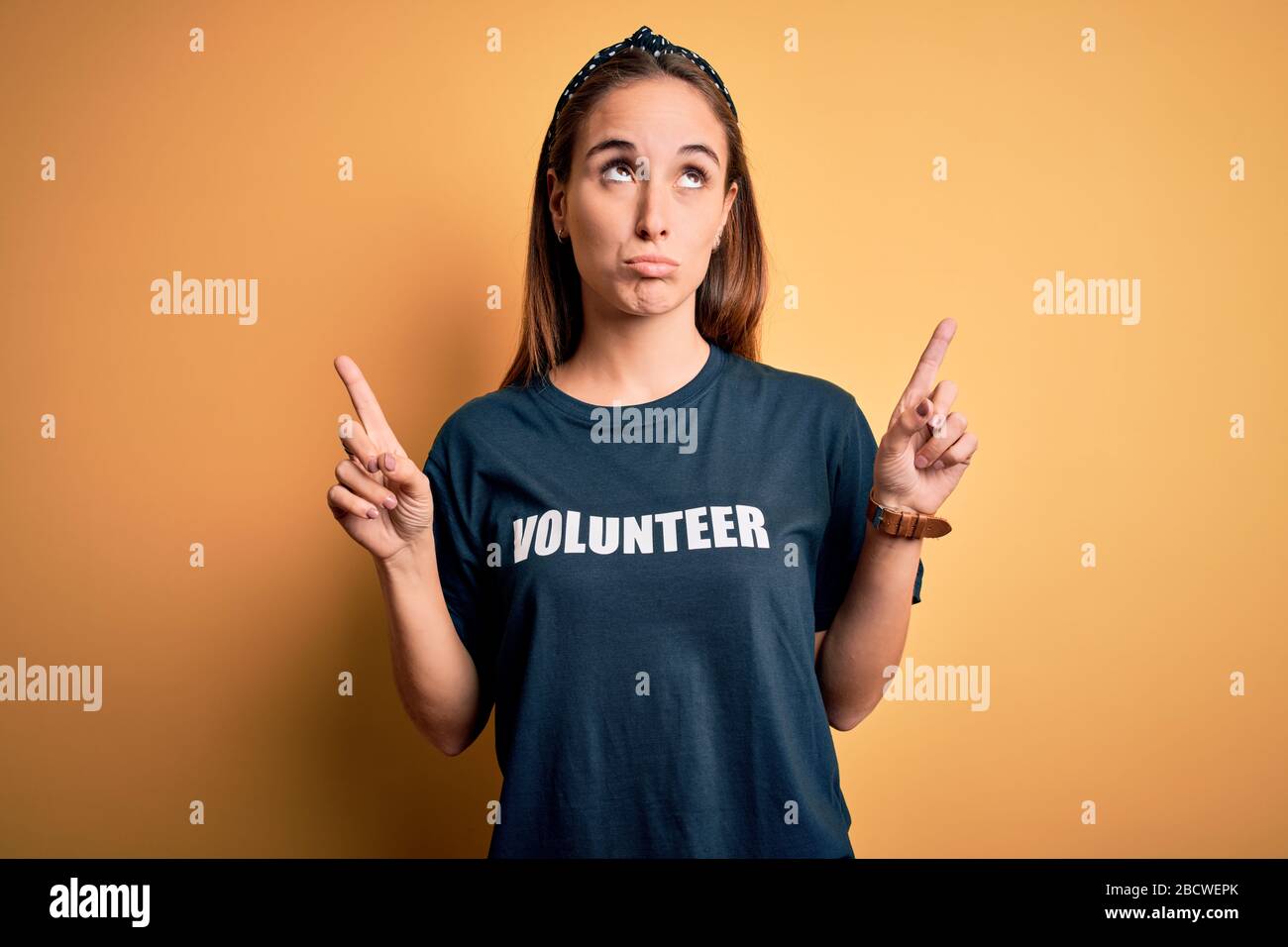 Young beautiful woman wearing volunteer t-shirt doing volunteering over ...