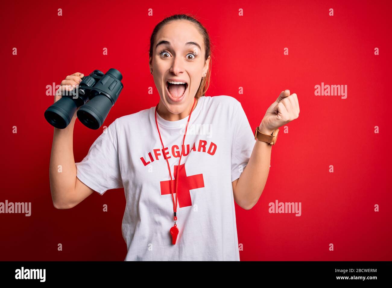 Young beautiful lifeguard woman wearing t-shirt with red cross and ...