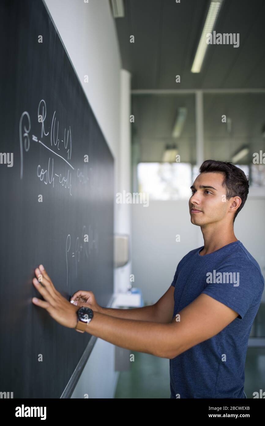 Students in a classroom - handsome student solving a math problem on a ...