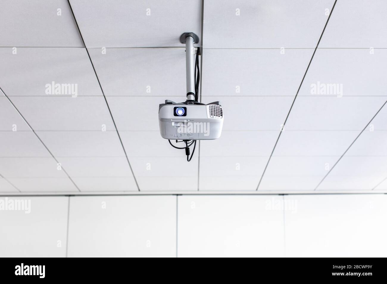A white overhead projector on ceiling in a conference room/modern ...