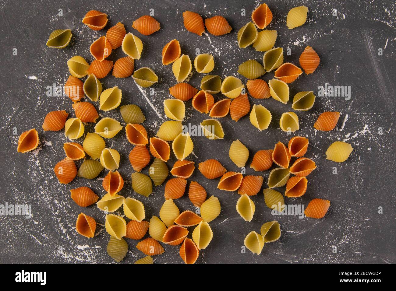 Pasta Conchiglie Rigate, mix of colorful uncooked shells. Textured ...