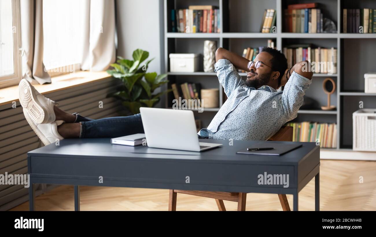 African American male lean in chair relaxing at workplace Stock Photo ...